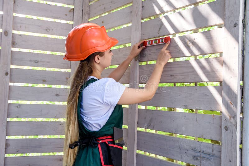 Woman with Measure Level Tool on Construction Site. Woman Measuring ...