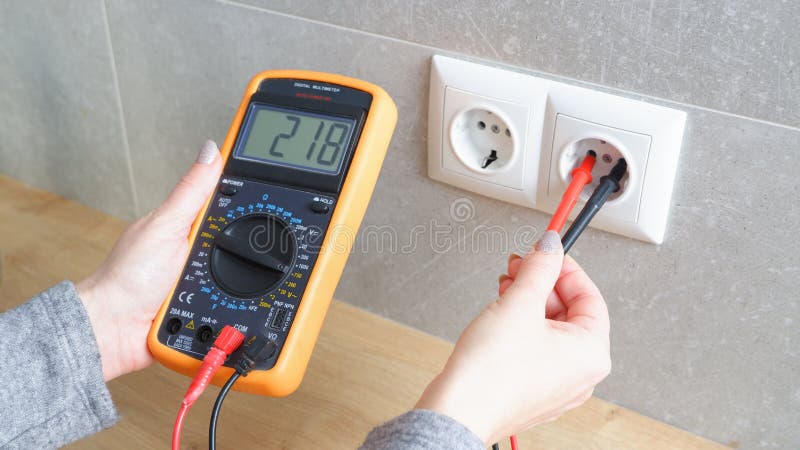 Woman with a Multimeter Check the Voltage of the Electrical Network ...