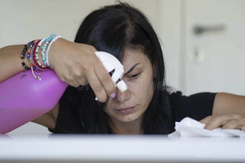 Woman with Obsessive Compulsive Disorder Cleaning Table with Detergents ...
