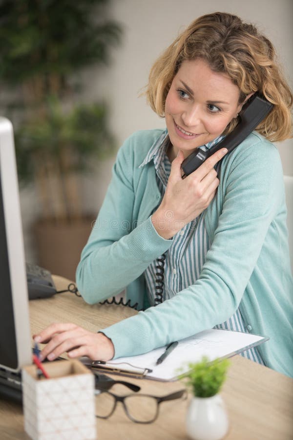 Woman at Office Desk Talking on Landline Stock Image - Image of ...