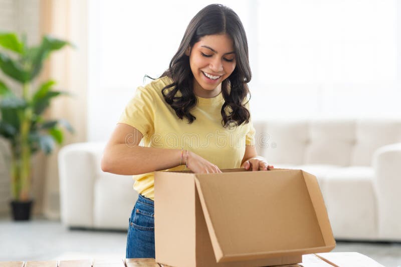 Woman Opening a Box on a Table, Looking Inside Stock Image - Image of ...
