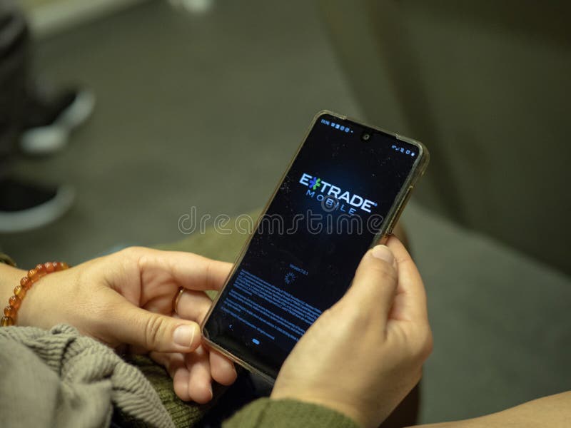 Woman Opening E-Trade Mobile App with Logo on Android Screen while ...