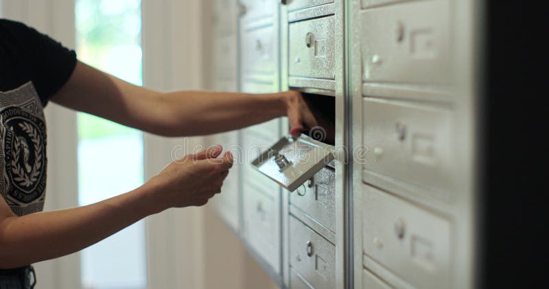 Woman is Opening Her Mailbox Inside a Cluster of Mailboxes for Her ...