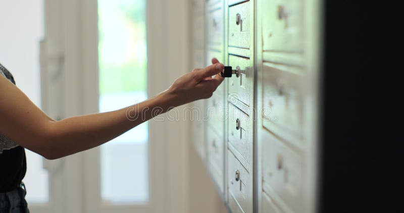 Woman is Opening Her Mailbox Inside a Cluster of Mailboxes for Her ...