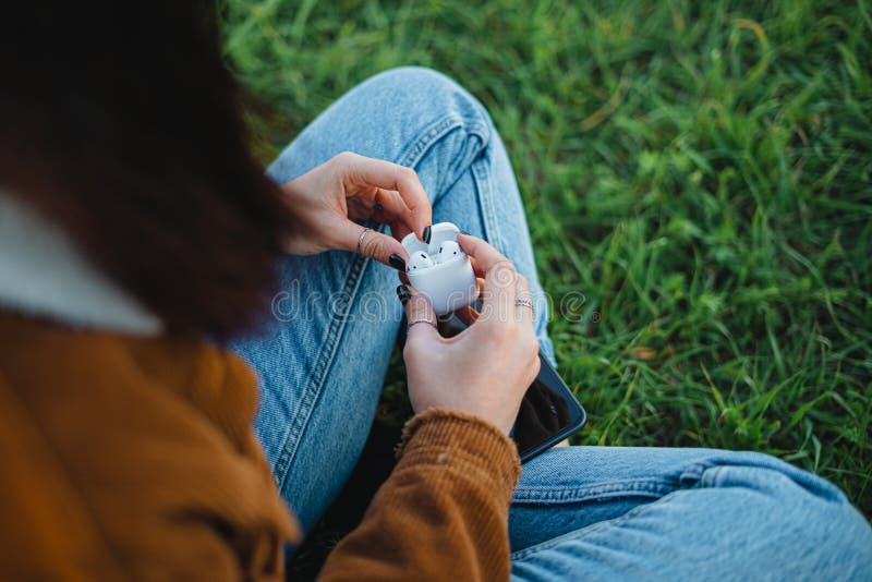 A Woman Opening Wireless Ear-buds Stock Image - Image of grass ...