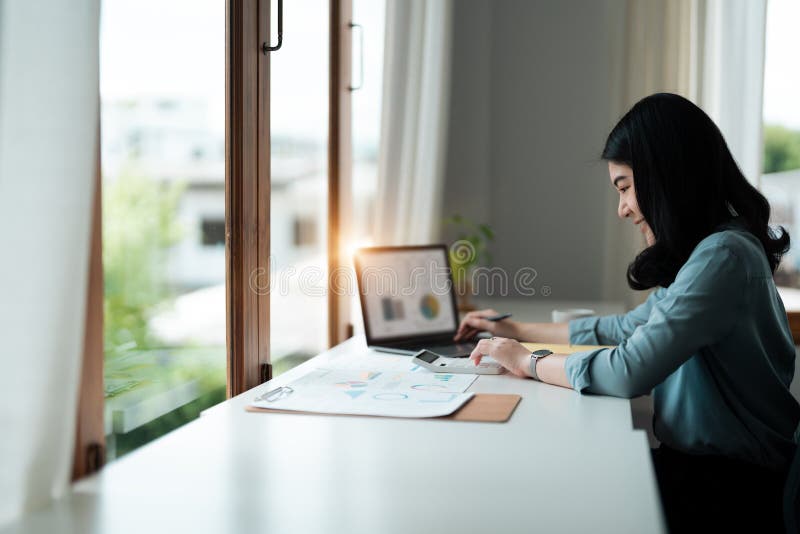 Woman with Paperwork Using Calculator and Laptop Computer Working at ...