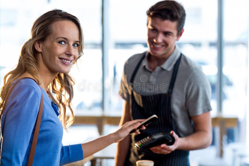 Woman Paying Bill through Smartphone Using NFC Technology Stock Photo ...
