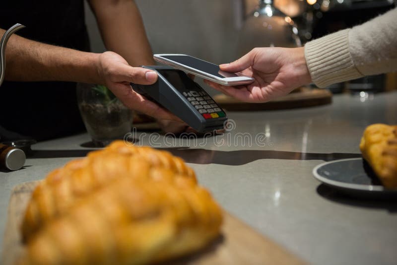 Woman Paying Bill through Smartphone Using NFC Technology Stock Photo ...