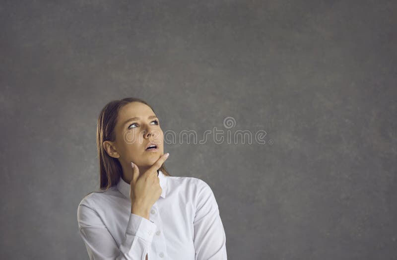Woman with a Pensive Expression Standing on a Gray Background Thinking ...