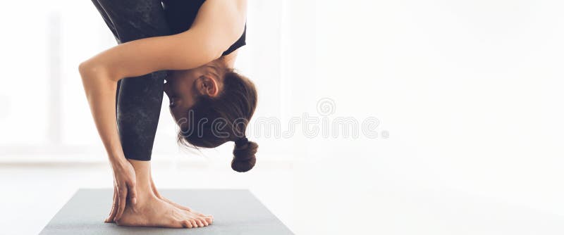 Woman Practicing Yoga with a Forward Bend Pose in a Bright Room Stock ...