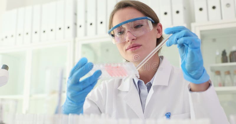 Woman Performs Precise Sample Analysis with Pipette and Plate Stock ...