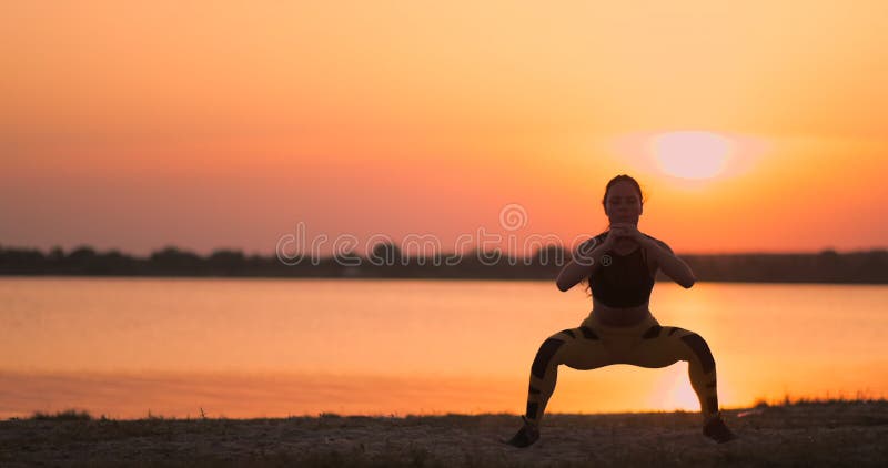 A Woman Performs Sit-UPS at Sunset on the Beach in Slow Motion ...