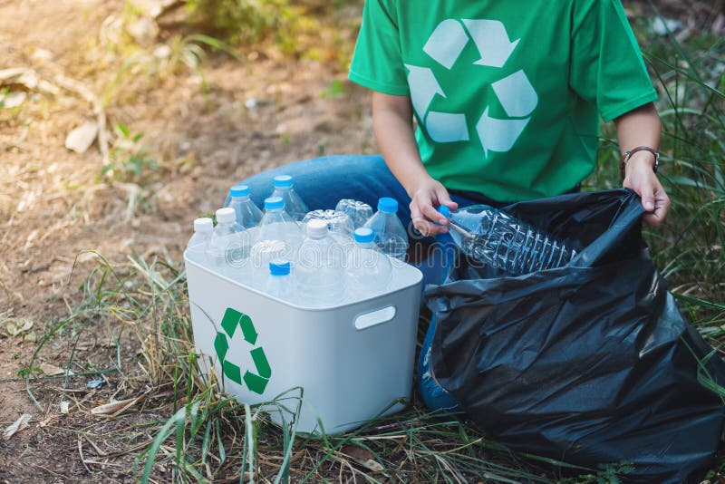 A Woman Picking Up Garbage Plastic Bottles into a Box and Bag Stock ...