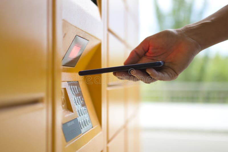 Woman Picking Up Her Package from an Automated Locker with a Bar Code ...
