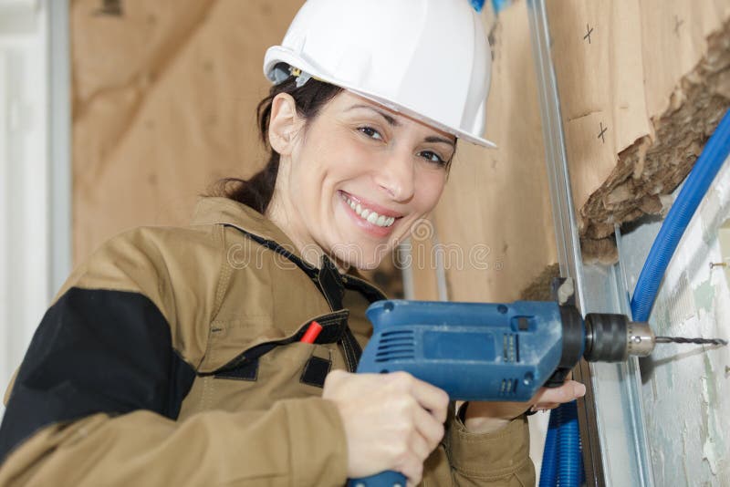 Woman Plasterer Drilling Wall Stock Photo - Image of effecient, smiling ...