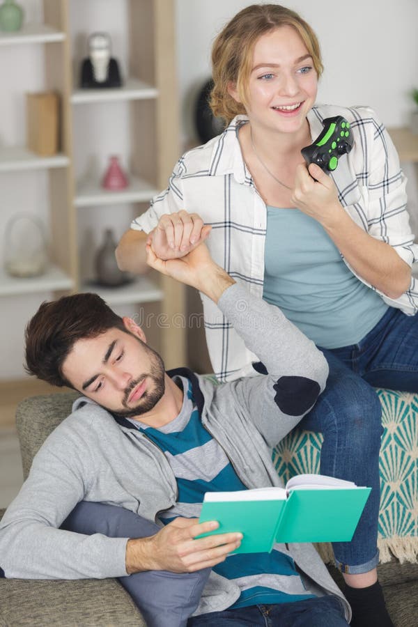 Woman Playing Games with Man Reading Book Stock Photo - Image of buying ...