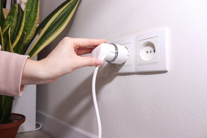 Woman Plugging Cable into Smart Plug Stock Photo - Image of electric ...