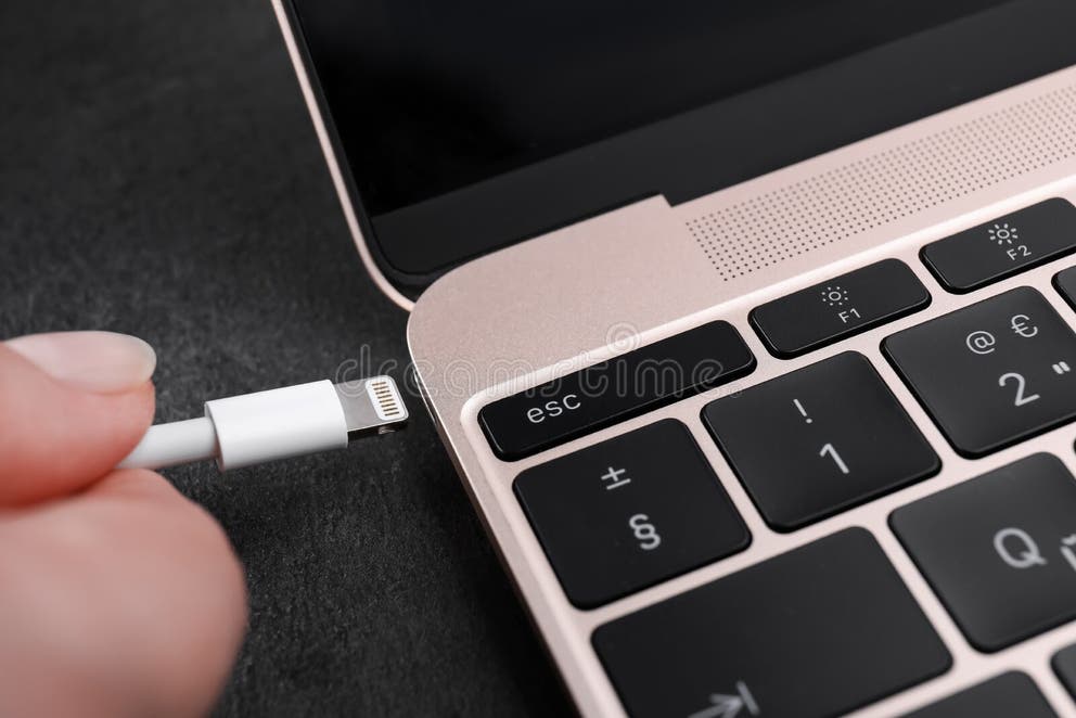 Woman Plugging USB Cable with Lightning Connector into Laptop Port on ...