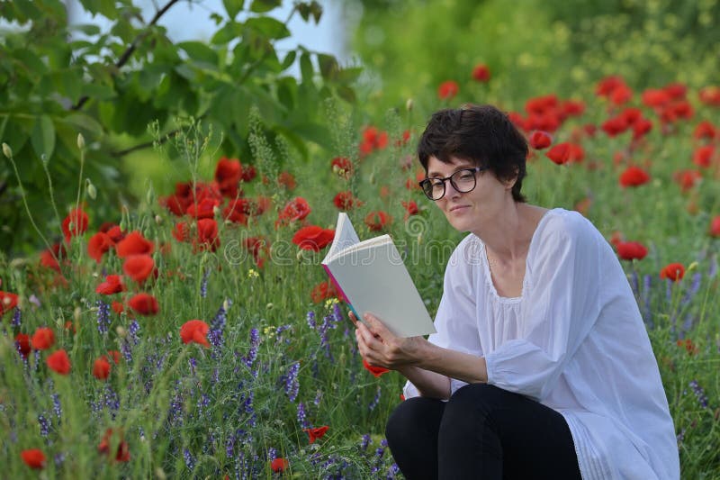 Woman in a Poppy Field Reading a Book Stock Image - Image of hands ...