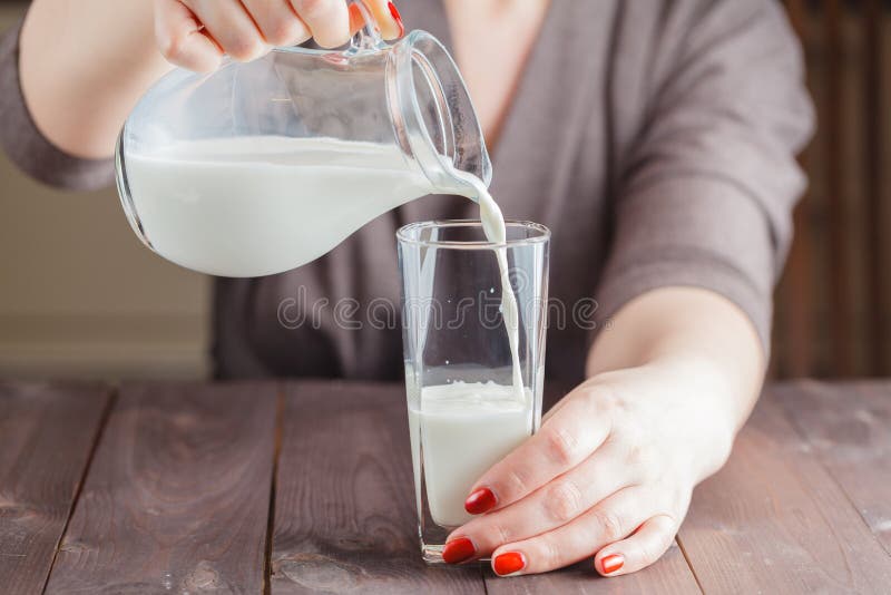 Woman Pour Out Milk into Glass Stock Image - Image of ewer, liquid ...