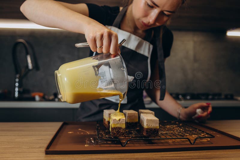 Woman Pouring Cream on a Plate of Layered Brown Cake with Raspberry on ...