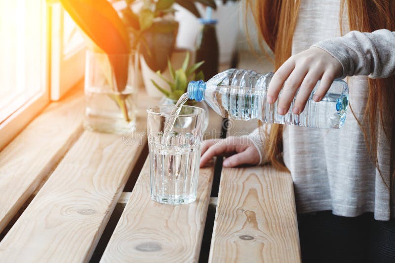 Woman Pouring Fresh Drink Water from Blue Plastic Bottle Inside Stock ...