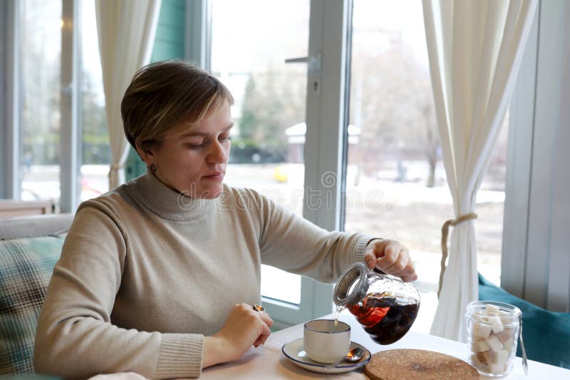Woman pouring tea in cafe stock image. Image of caucasian - 203788361