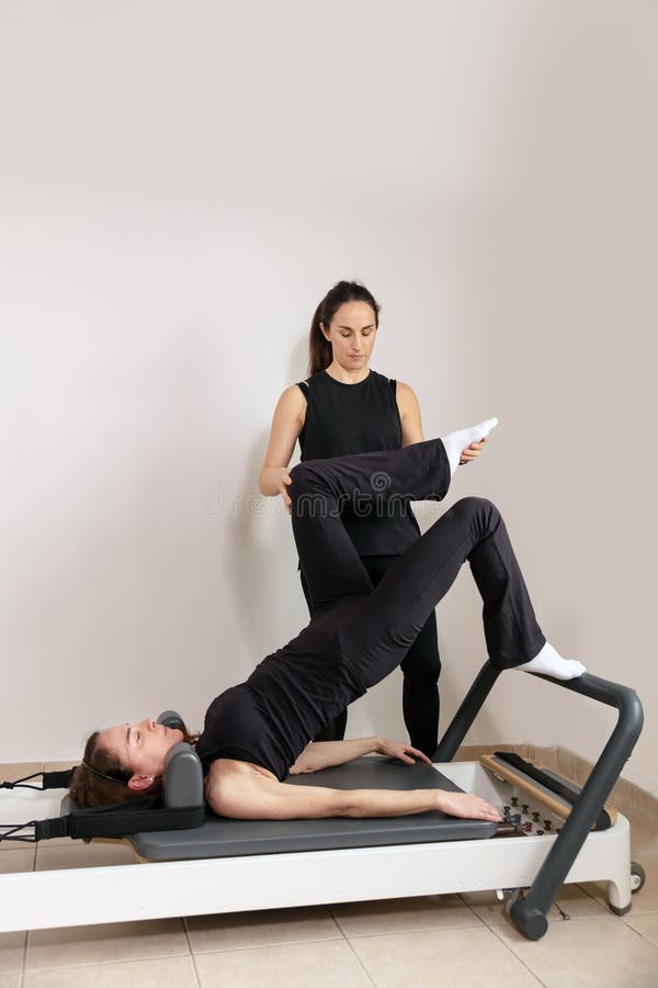 A Woman Practicing Exercises with a Pilates Personal Trainer. Stock ...
