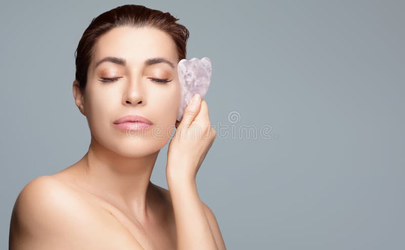 Woman Using Gua Sha for Facial Massage and Anti-aging Skin Care ...