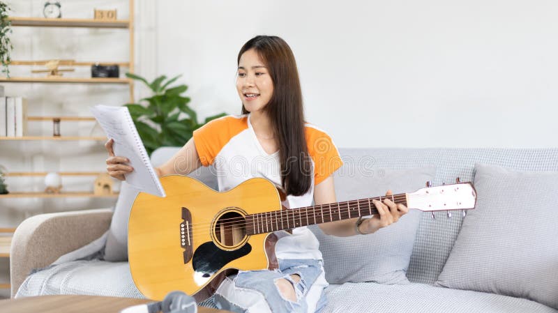 Woman Practicing or Learning To Play Guitar and Practice Using His ...
