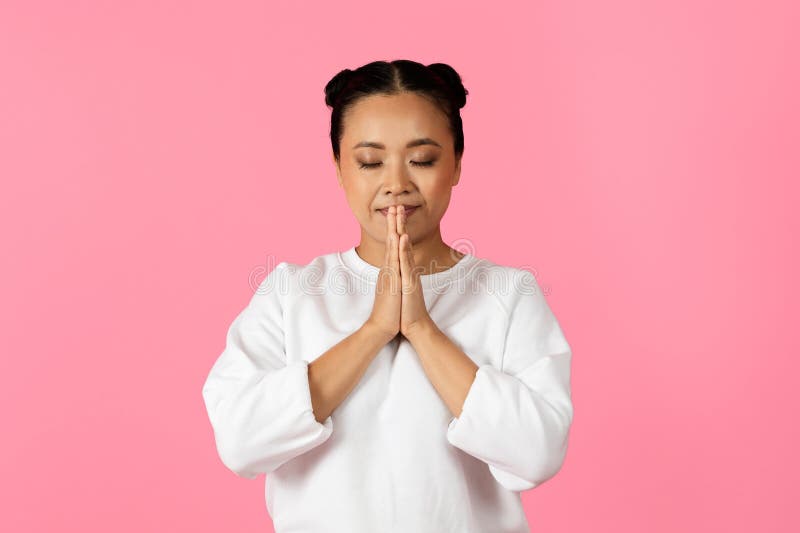 Woman Practicing Mindfulness with Hands Together in Front of a Pink ...