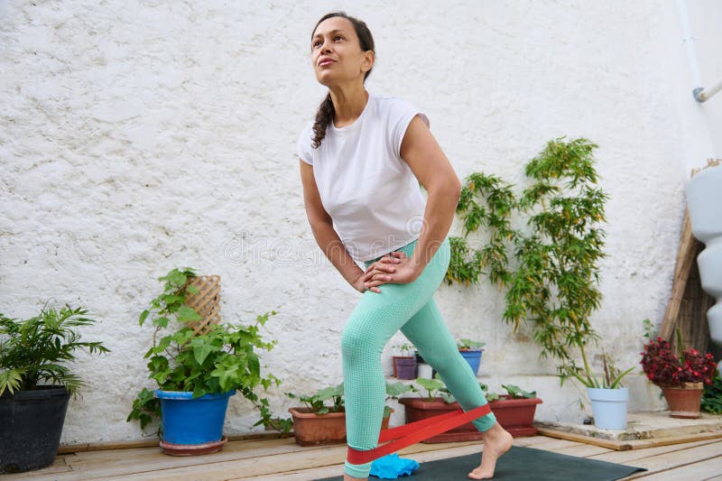 Woman Practicing Resistance Band Workout in Outdoor Garden Setting ...