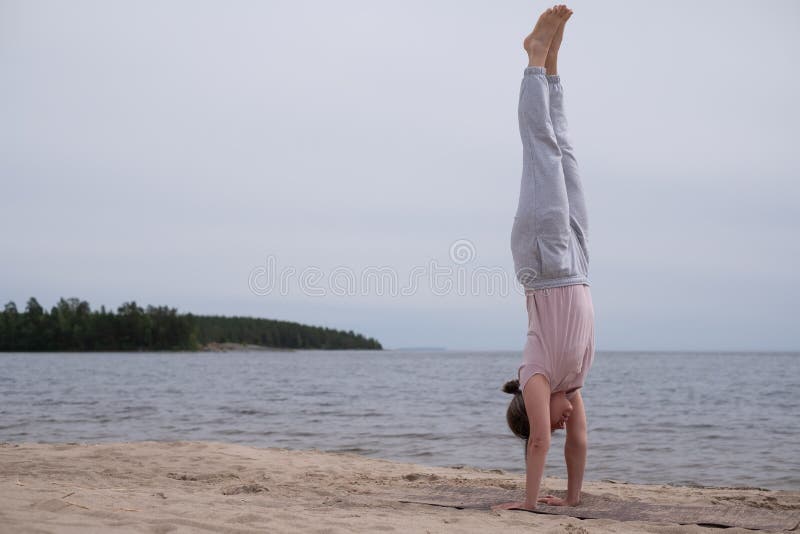Woman Practicing Yoga Doing Handstand on Beach Outdoor. Stock Image ...