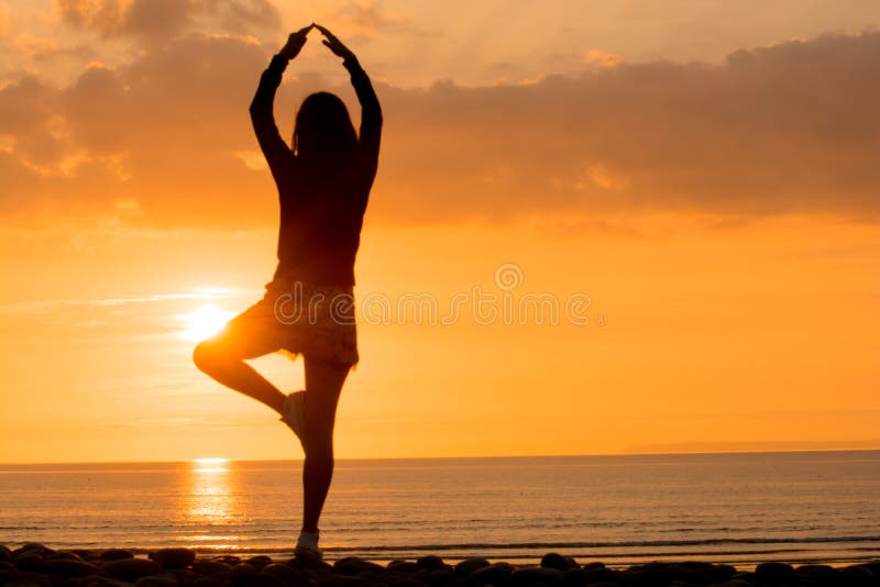 Woman Practising Yoga at Sunset on the Beach Stock Photo - Image of ...