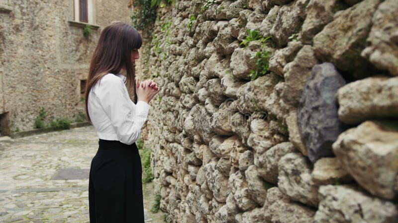 Woman Praying with Focus in Front of the Sacred Wall Stock Video ...