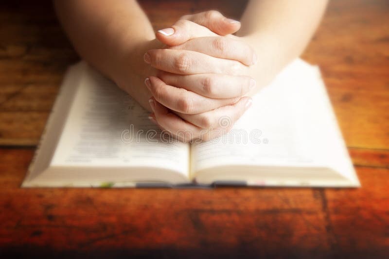 Woman Praying with Her Hands Folded Over Her Bible Stock Image - Image ...