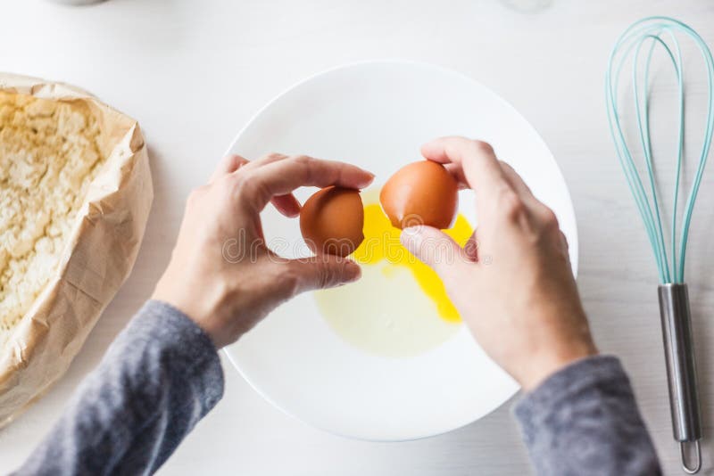 A Woman Prepares the Dough for the Pie, Breaks an Egg into a Cup. on ...