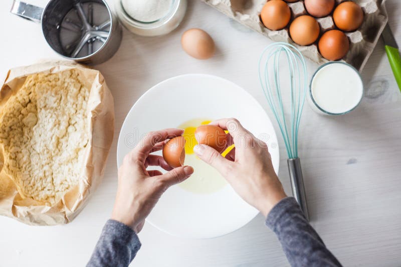 A Woman Prepares the Dough for the Pie, Breaks an Egg into a Cup. on ...
