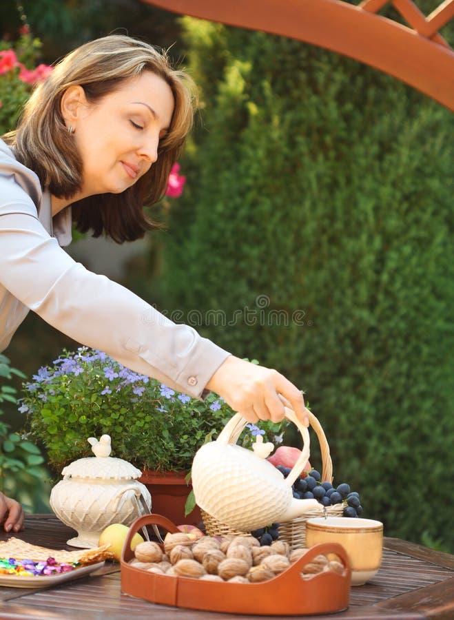 Woman Preparing Tea in Teapot in a Garden Stock Image - Image of autumn ...