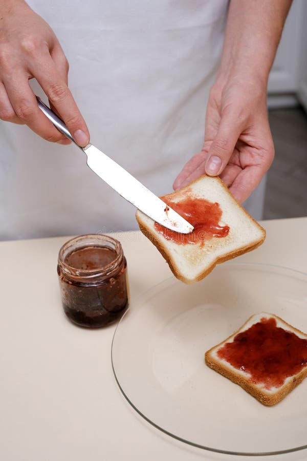 Young Woman Spreading Jam on Toast, Close-up of Hands Stock Photo ...
