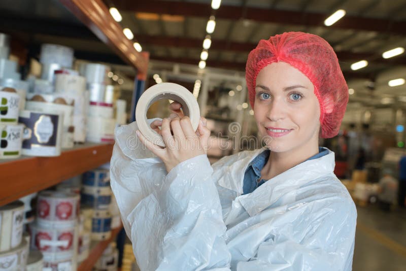 Woman in Protective Clothing in Hardware Store Holding Roll Tape Stock ...
