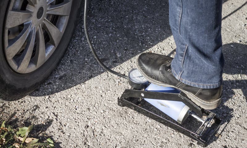 A Woman Pumps Air into the Wheels Using a Car Foot Pump Stock Image ...