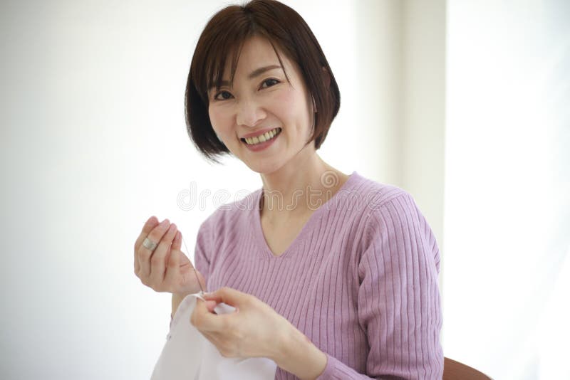 Woman Putting Buttons on Clothes Stock Photo - Image of handicraft ...