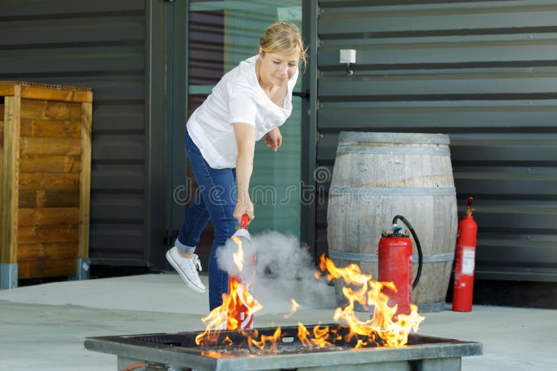 Woman Putting Fire Out with Extinguisher Stock Photo - Image of ...