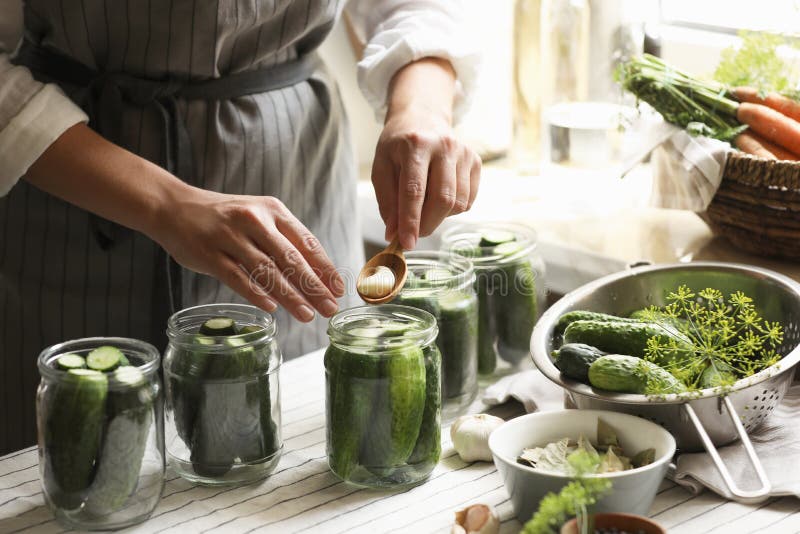 Woman Putting Garlic into Jar in Kitchen, Closeup. Canning Vegetables ...