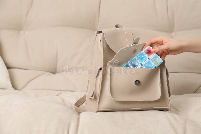Woman Putting Pill Box into Backpack on Sofa, Closeup Stock Image ...