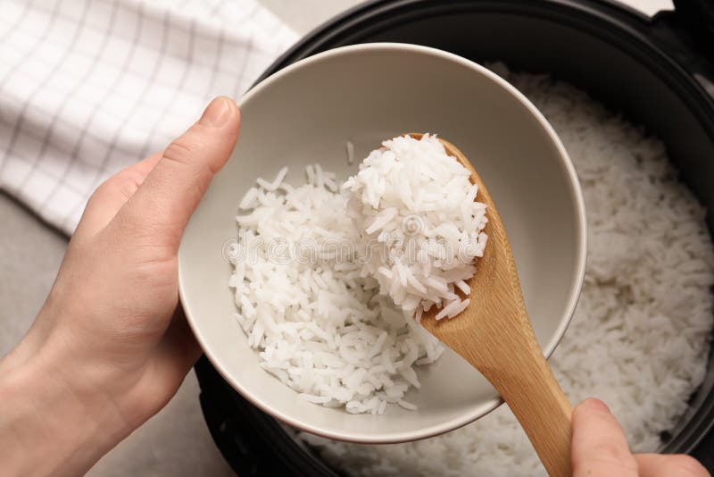 Woman Putting Rice into Bowl from Cooker in Kitchen Stock Image - Image ...