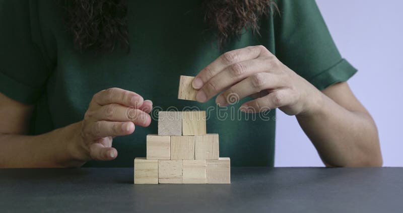 Woman Putting a Square Wood Block on Pyramid Stack of Wood Blocks Stock ...