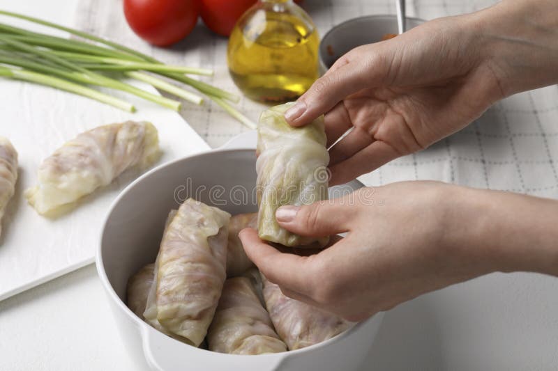 Woman Putting Uncooked Stuffed Cabbage Roll into Ceramic Pot at White ...