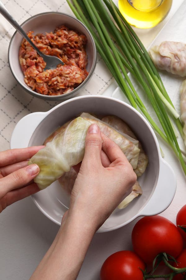 Woman Putting Uncooked Stuffed Cabbage Roll into Ceramic Pot at White ...